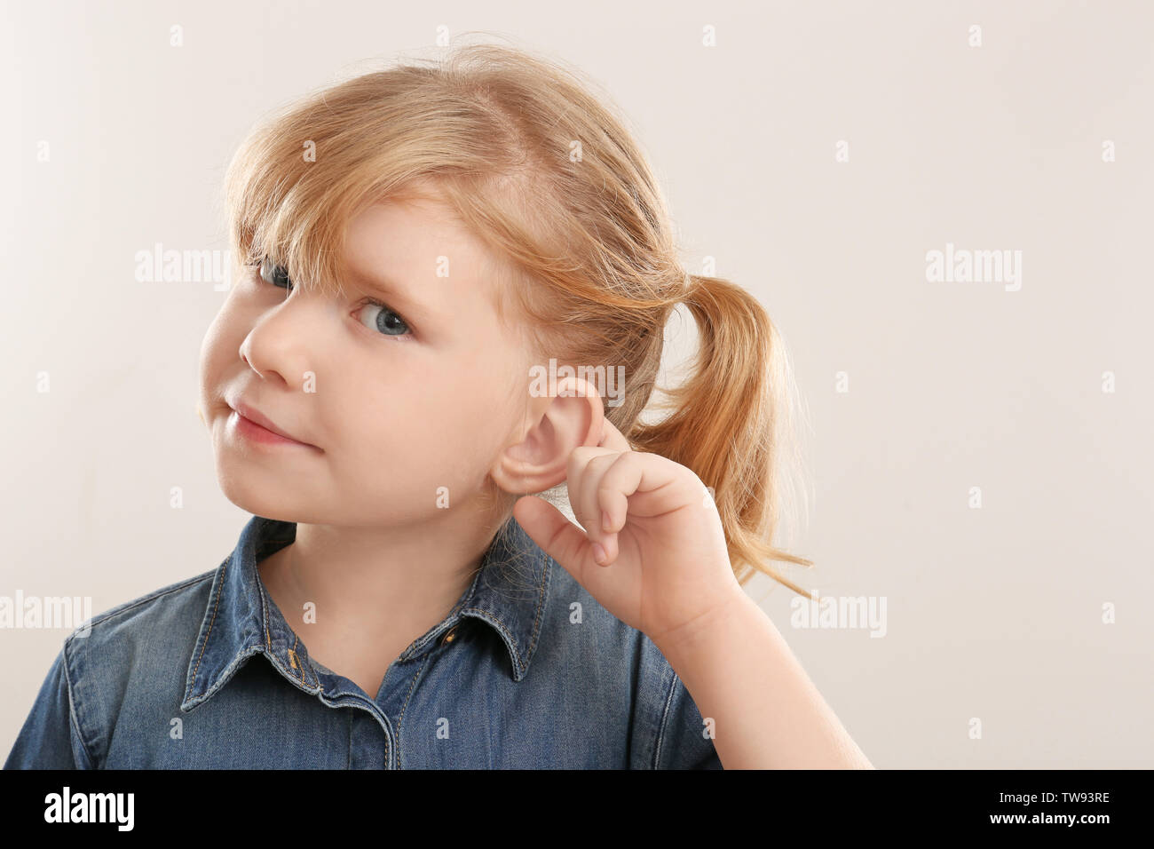 Cute little girl with hearing problem on light background Stock Photo ...