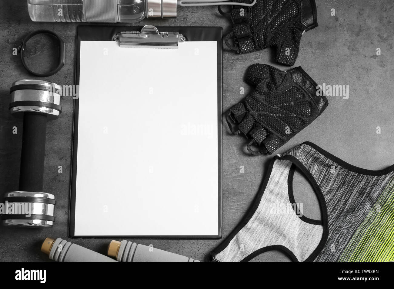 Clipboard with blank paper for exercise plan and gym stuff on grey ...