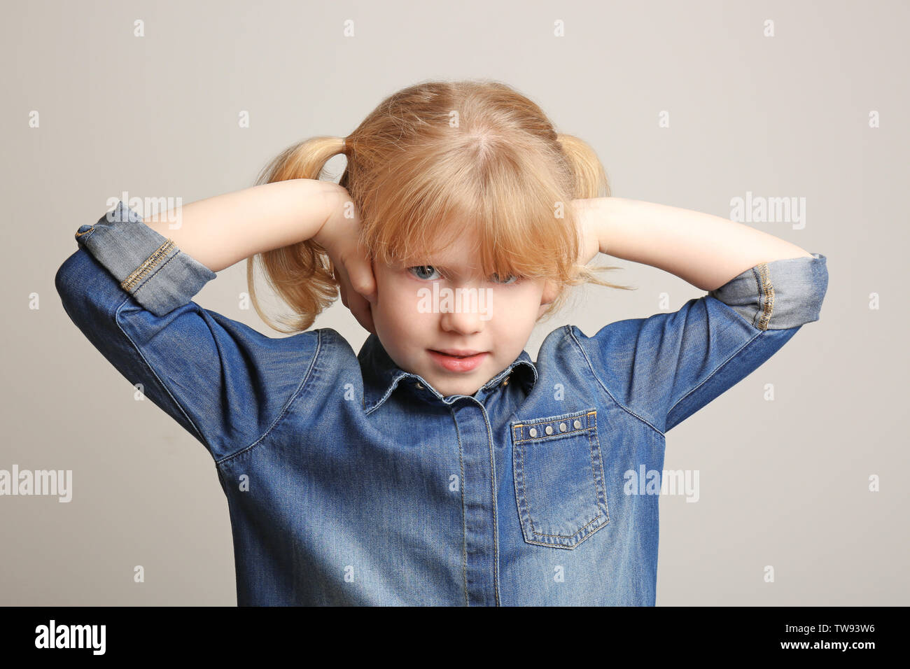 Cute little girl with hearing problem on grey background Stock Photo ...