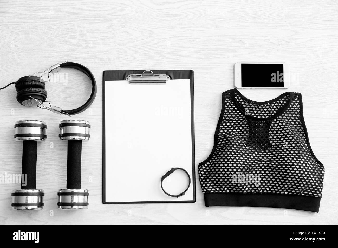 Clipboard with blank paper for exercise plan and gym stuff on wooden ...