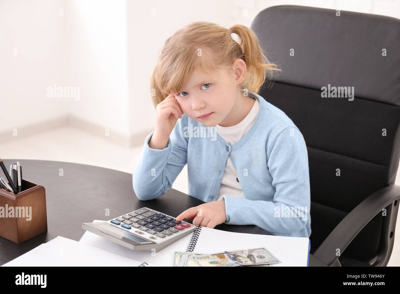 Cute little girl counting money at table indoors Stock Photo - Alamy