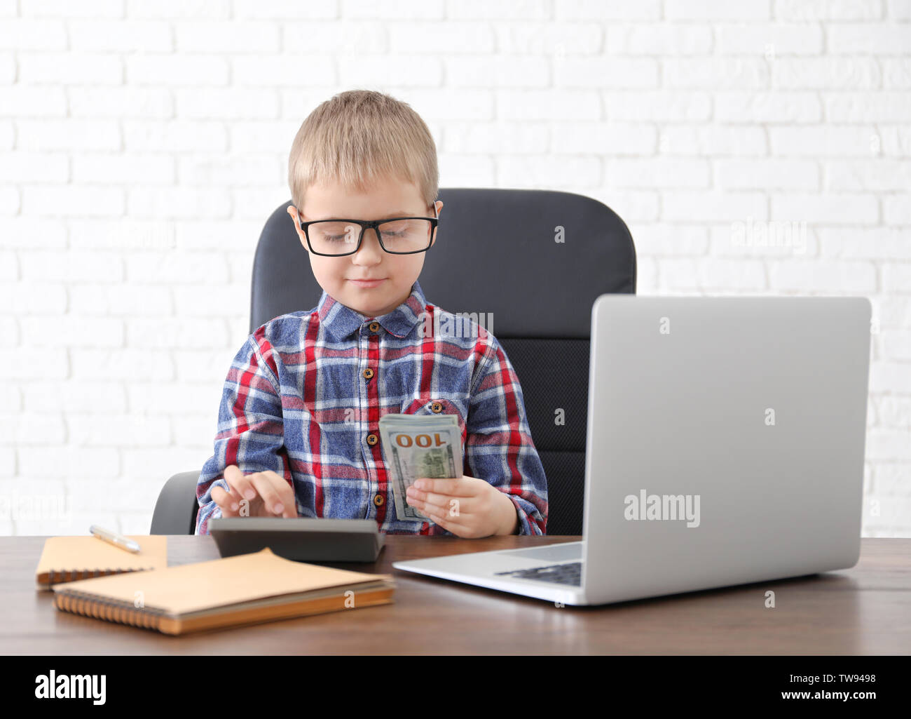 Cute little boy counting money at table indoors Stock Photo - Alamy