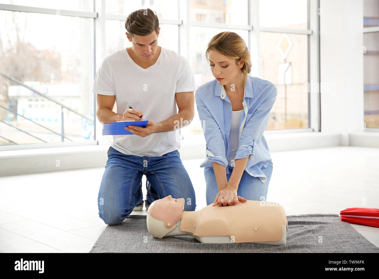 Young woman practicing CPR on mannequin in first aid class Stock Photo ...
