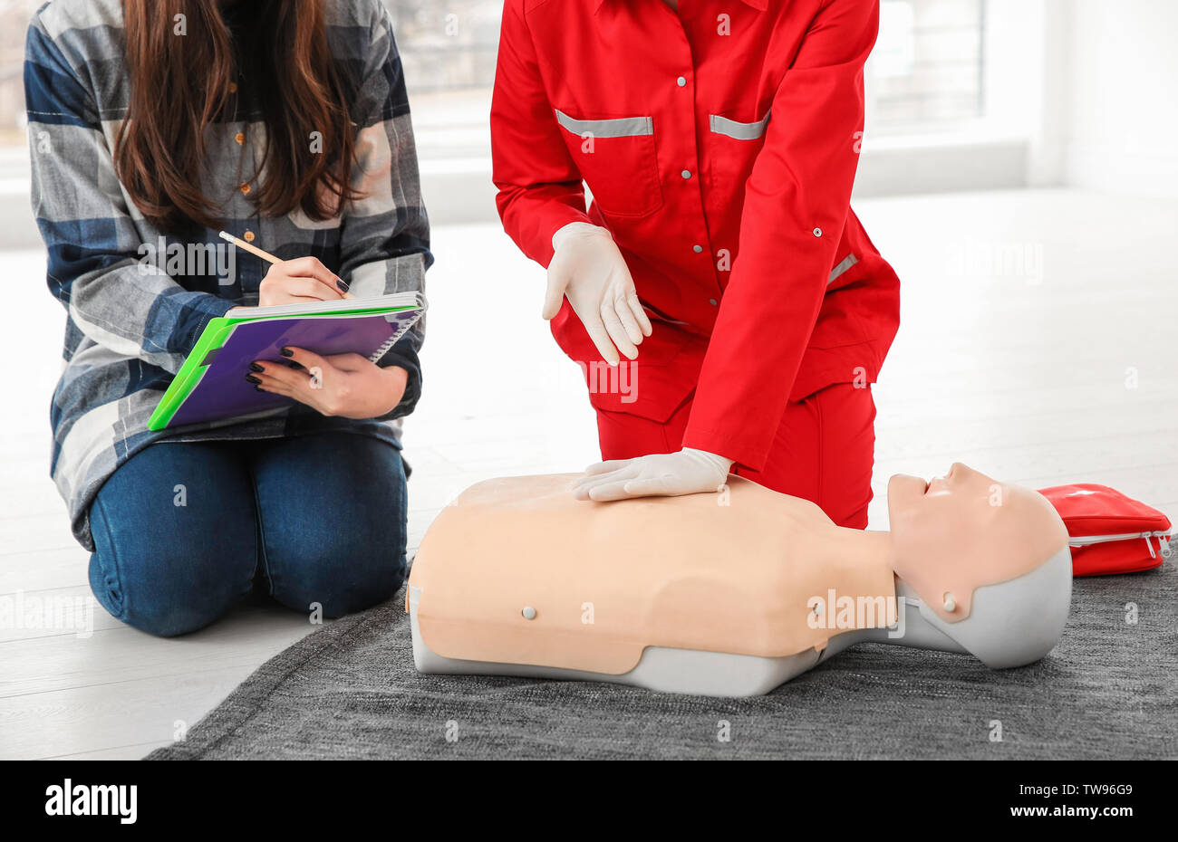 Woman demonstrating CPR on mannequin in first aid class Stock Photo - Alamy
