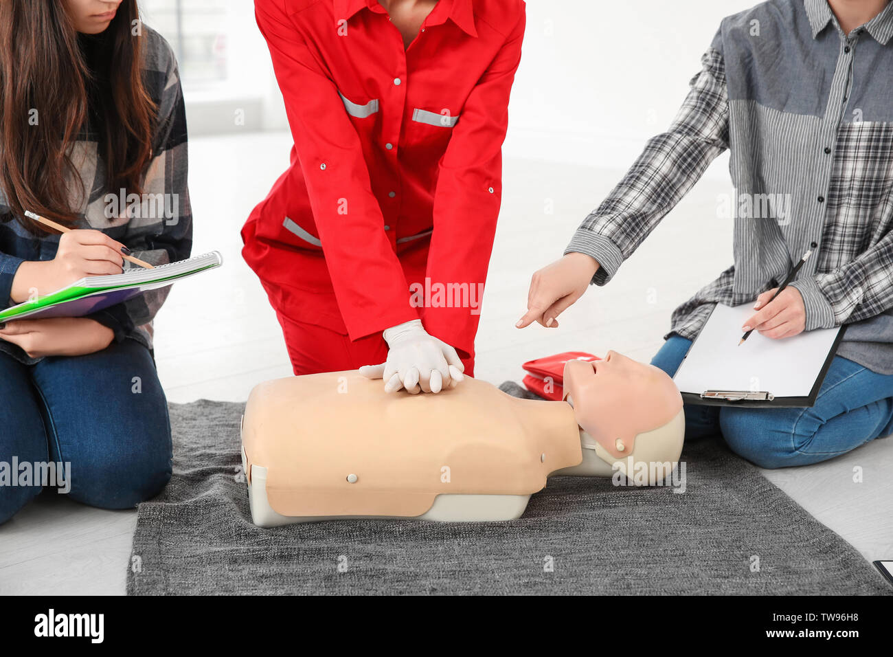 Woman demonstrating CPR on mannequin in first aid class Stock Photo - Alamy