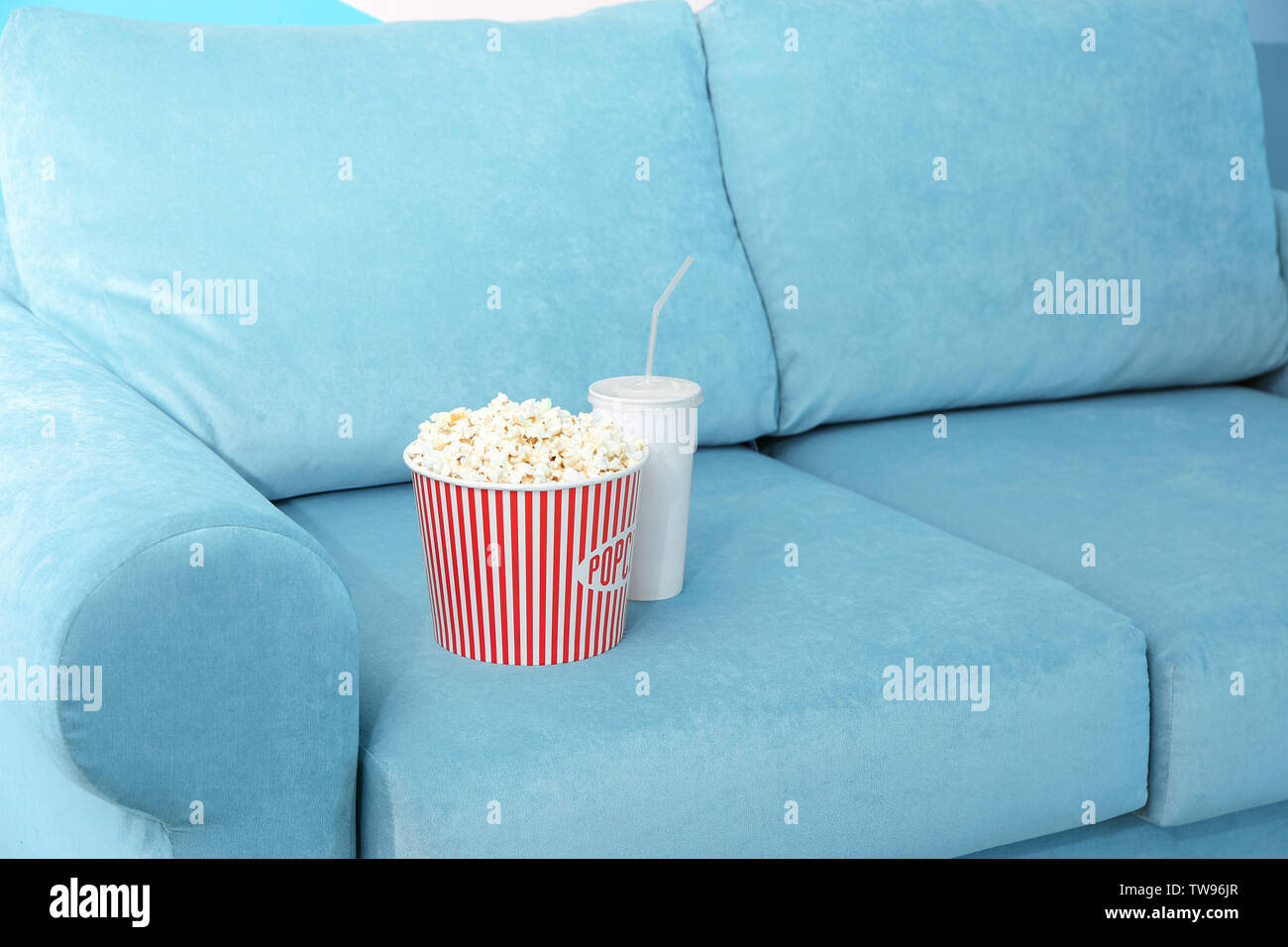 Comfortable couch with popcorn and drink, closeup. Home cinema Stock ...