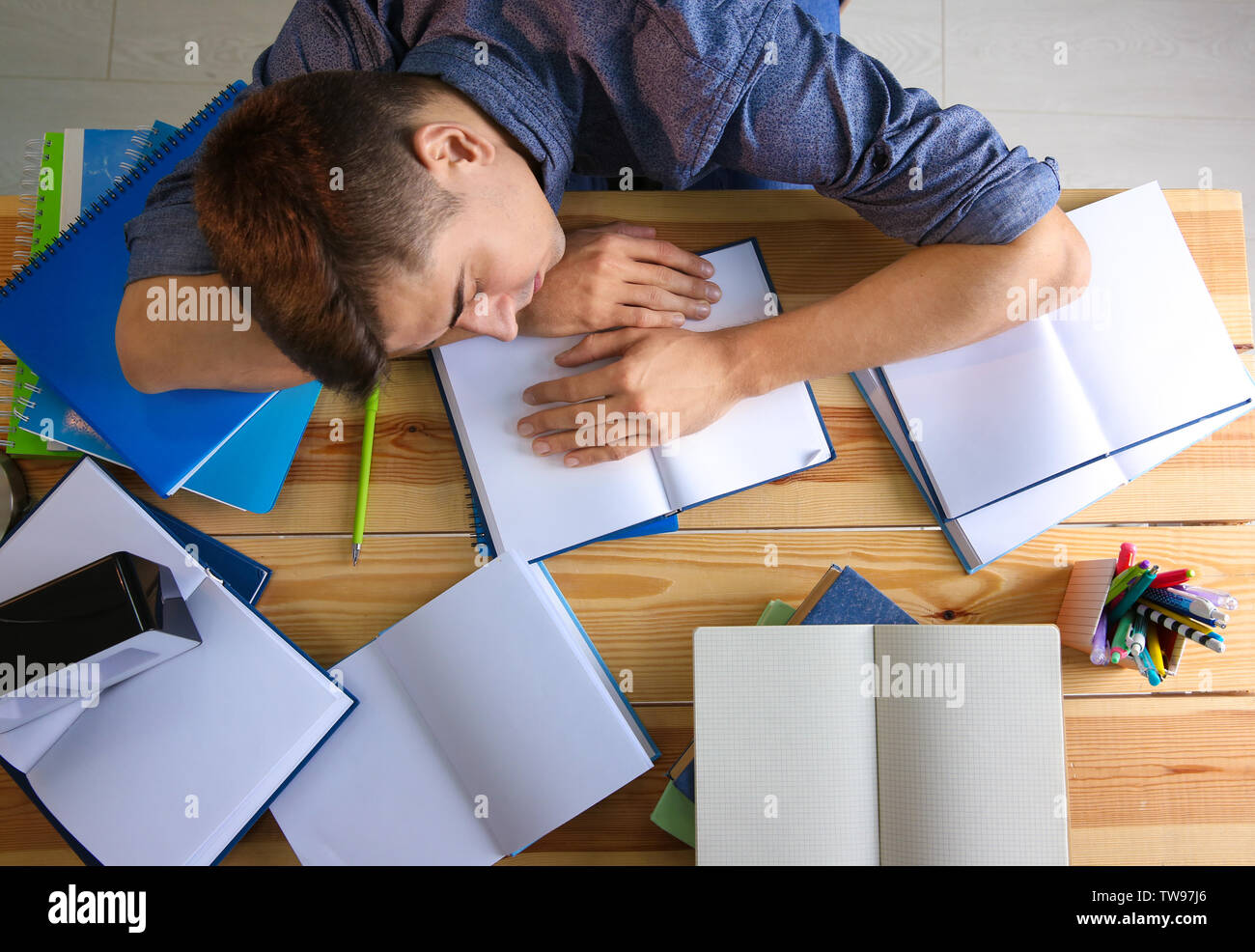 Tired student sleeping at his desk. Preparing for exam Stock Photo - Alamy