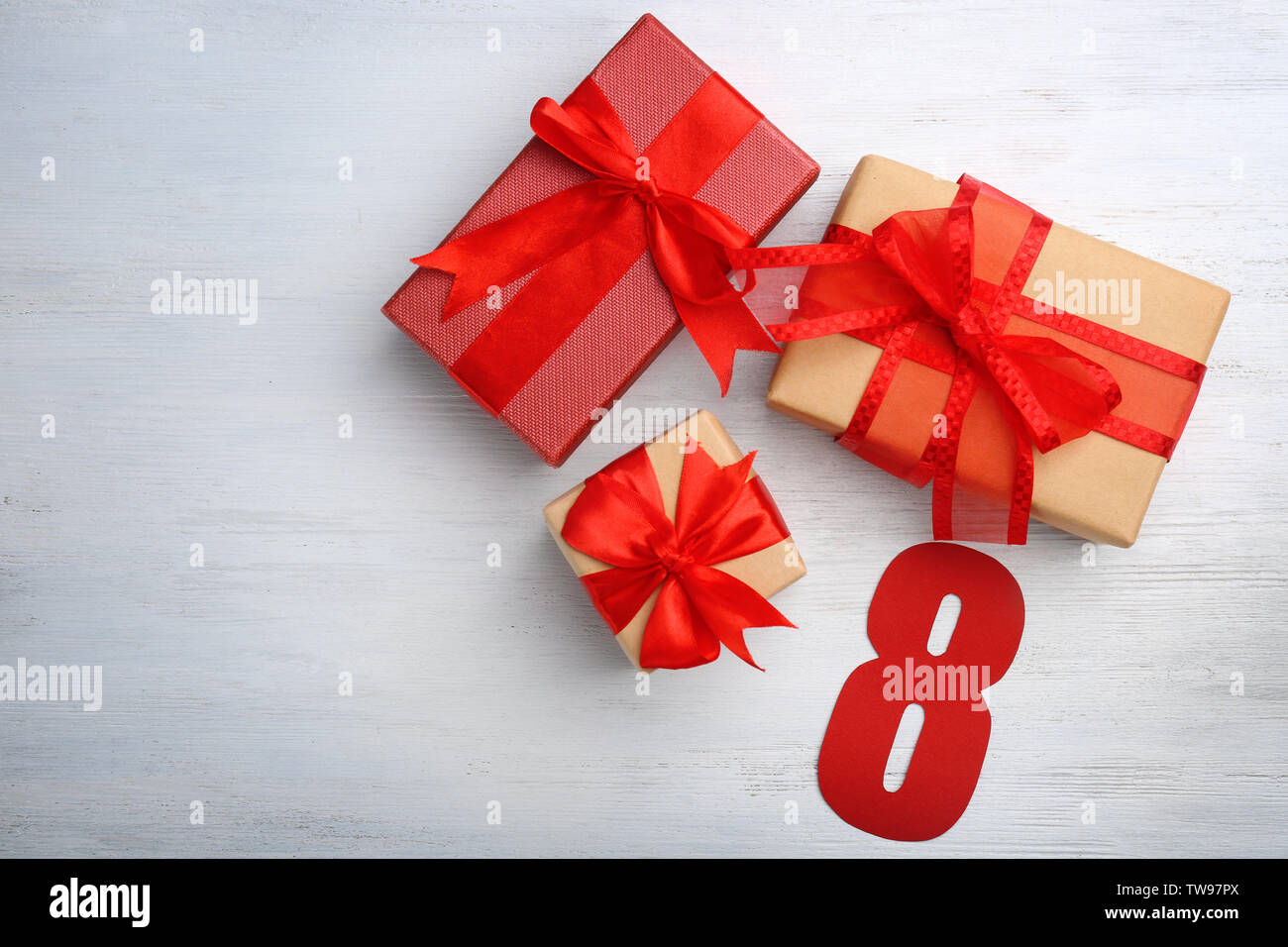 Paper figure 8 and gift boxes on wooden table. Composition for ...