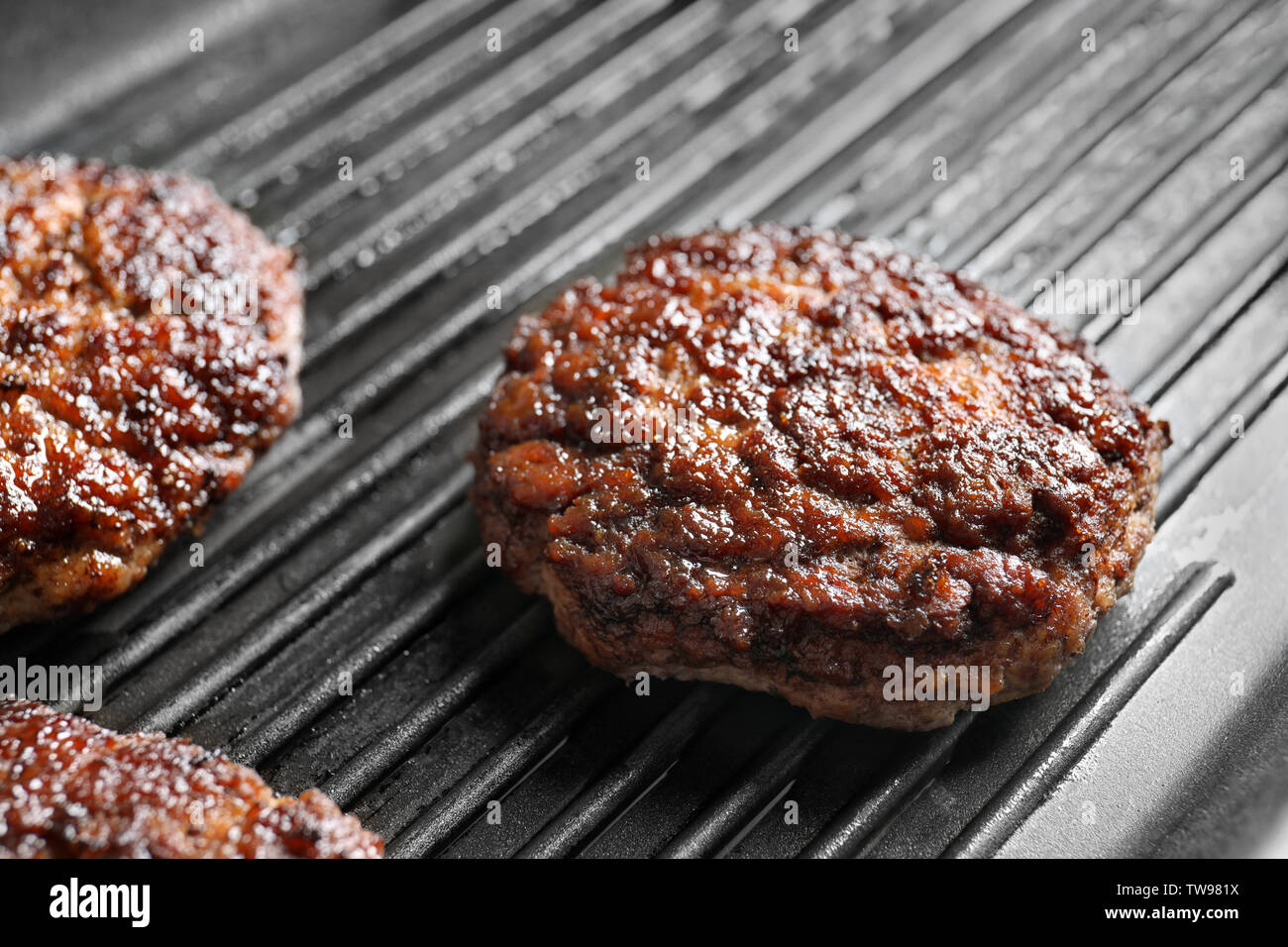 Burger patty on grill surface, closeup Stock Photo - Alamy
