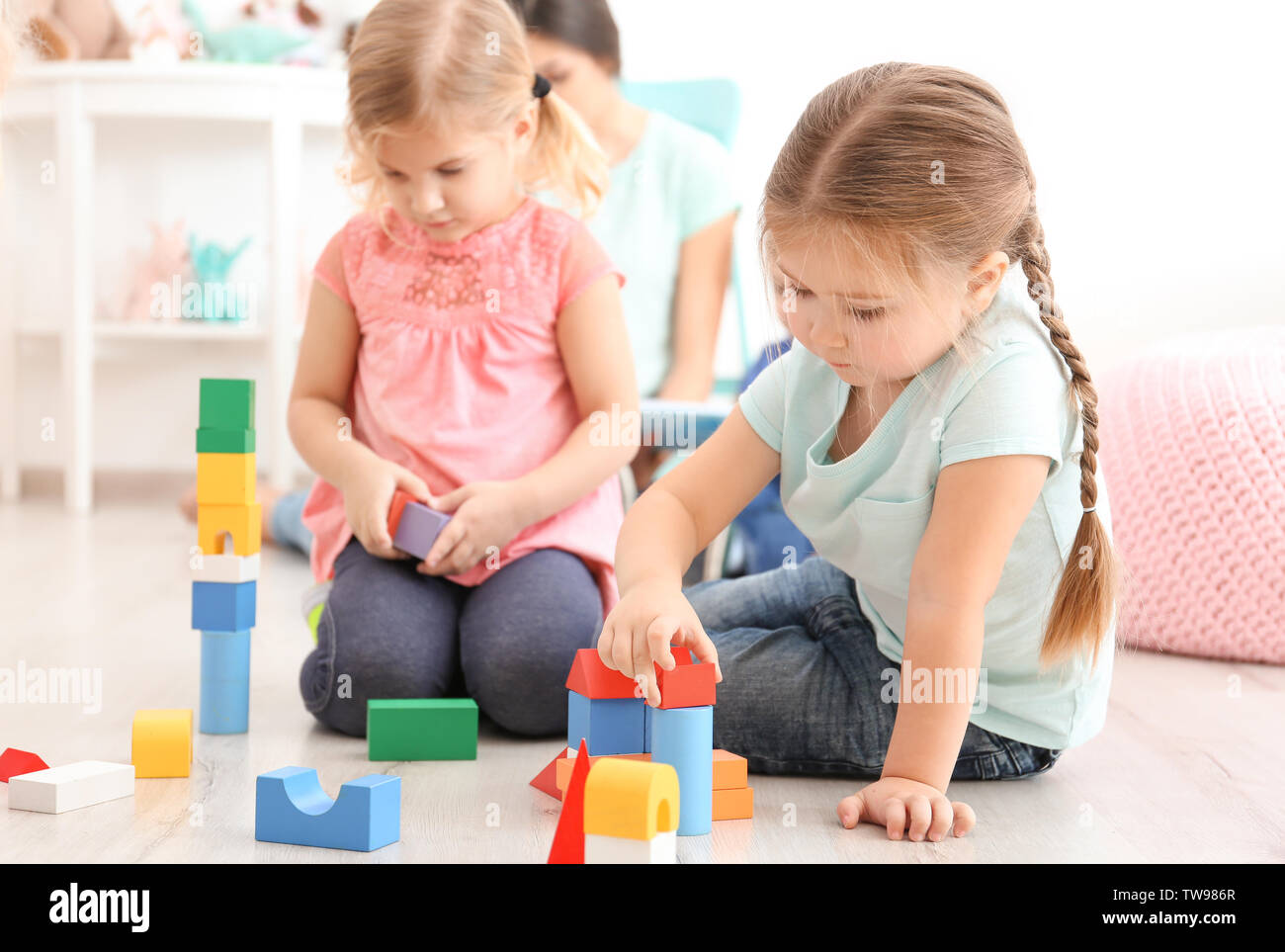 Cute little children playing with blocks in kindergarten Stock Photo ...