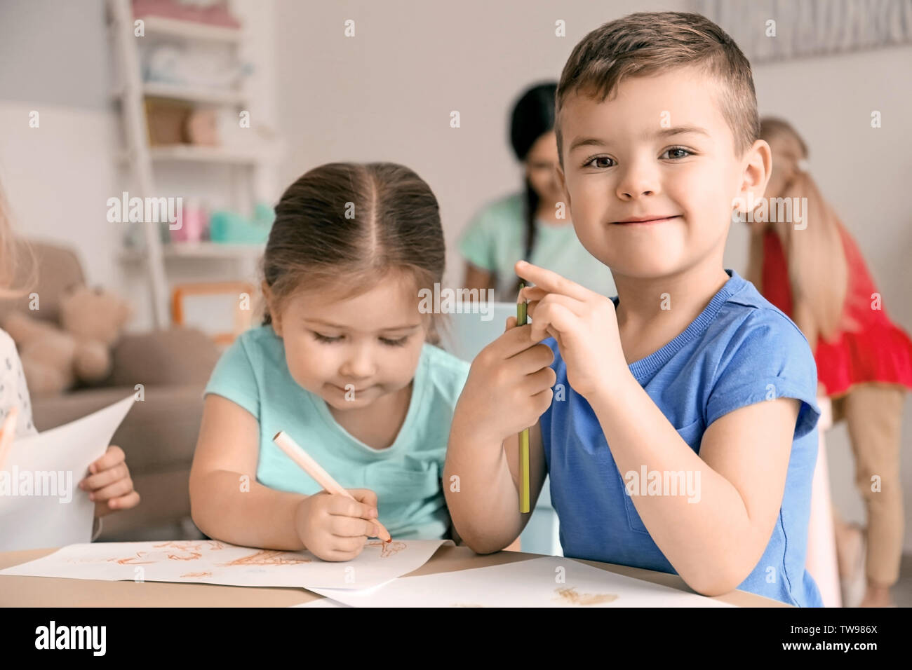 Cute little children drawing in kindergarten Stock Photo - Alamy