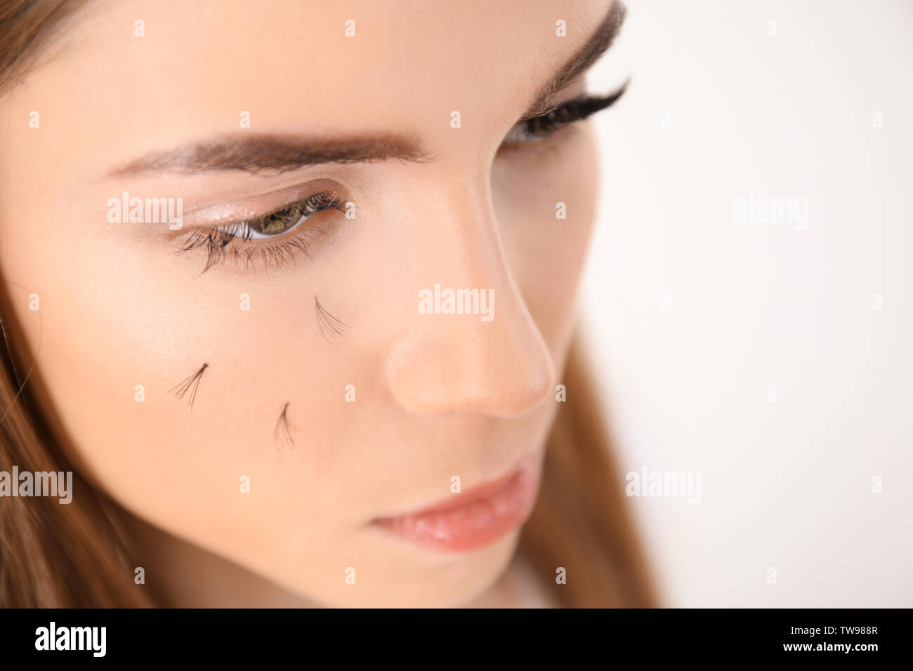 Young woman with eyelash loss problem on white background Stock Photo ...