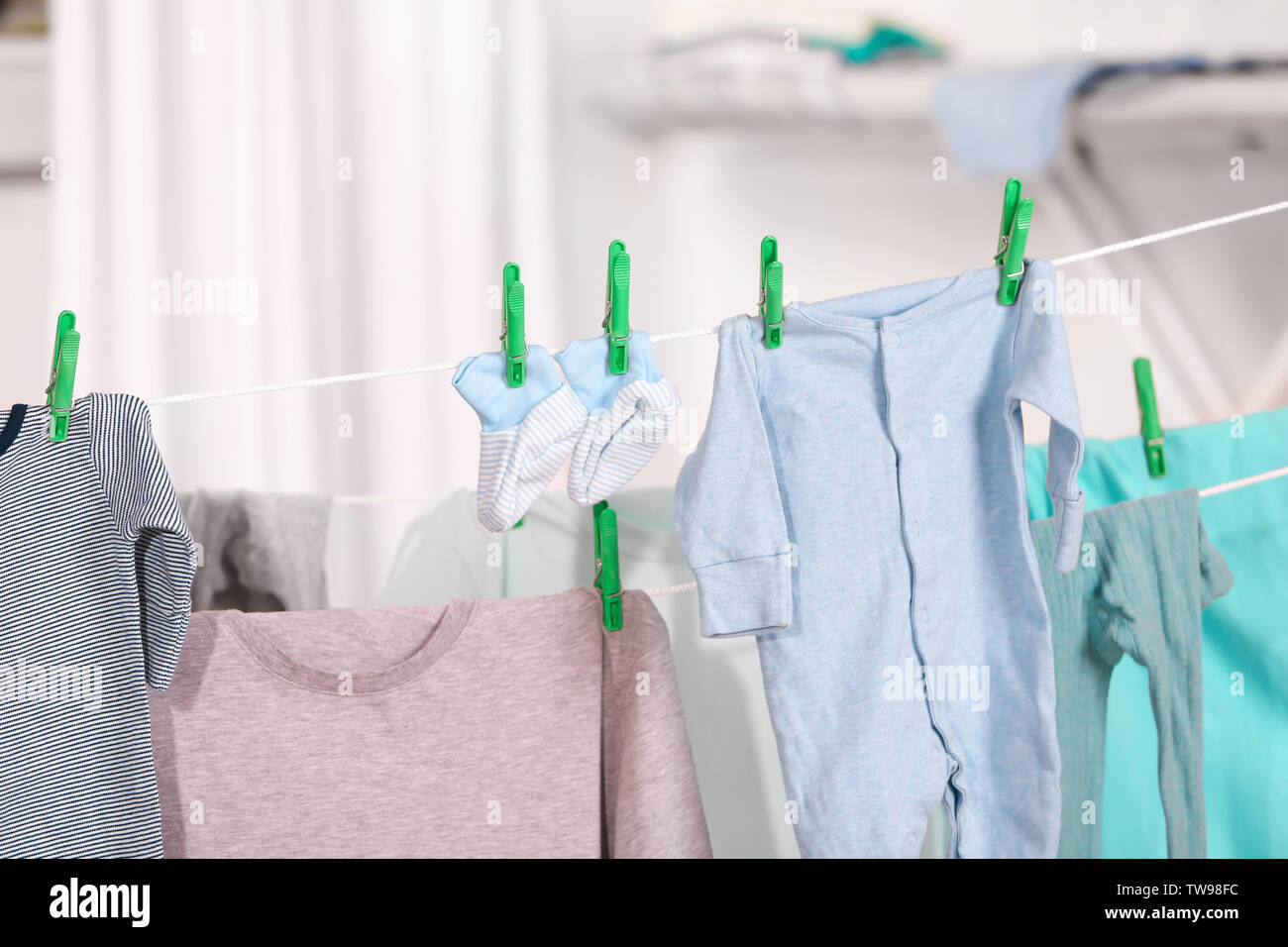 Clothes hanging on laundry line indoors Stock Photo - Alamy