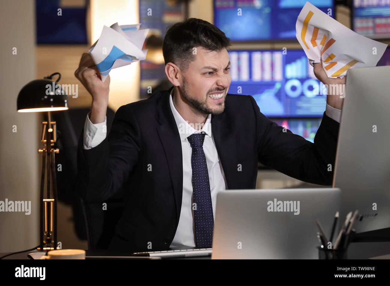 Emotional stock exchange trader with documents in office Stock Photo ...