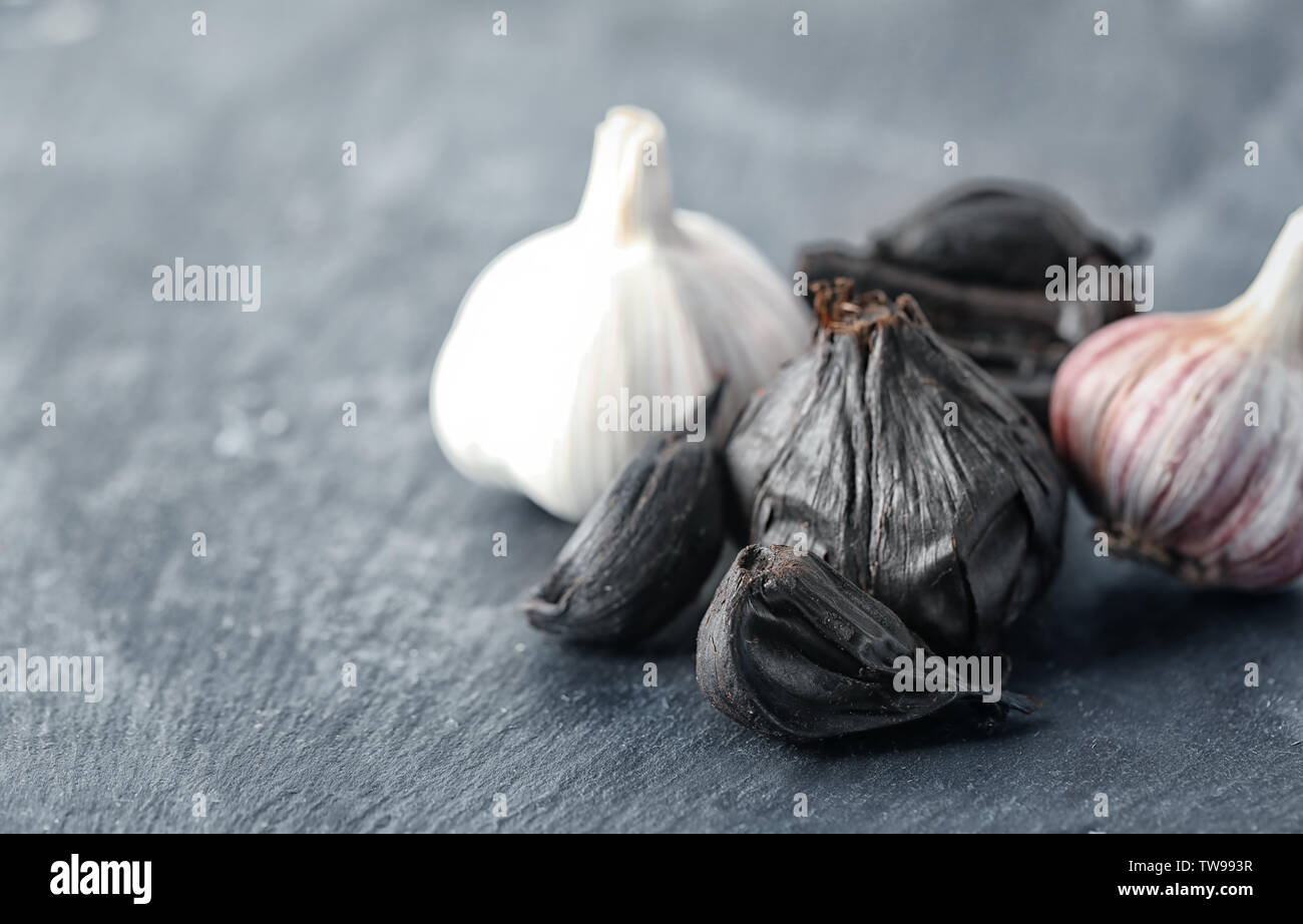 Black (Allium sativum) and white garlic bulbs on table Stock Photo - Alamy