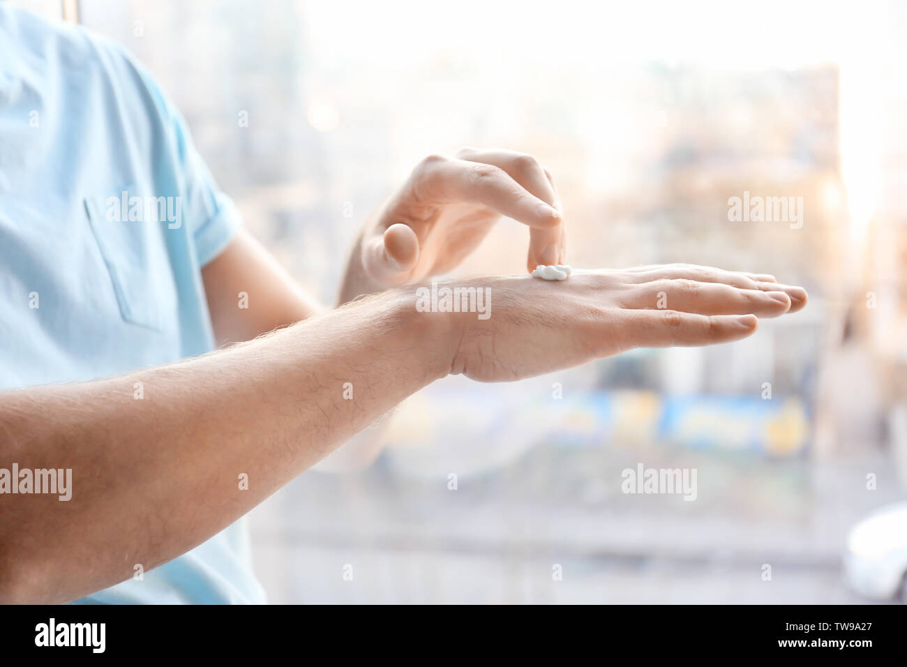 Man applying hand cream at home, closeup Stock Photo - Alamy