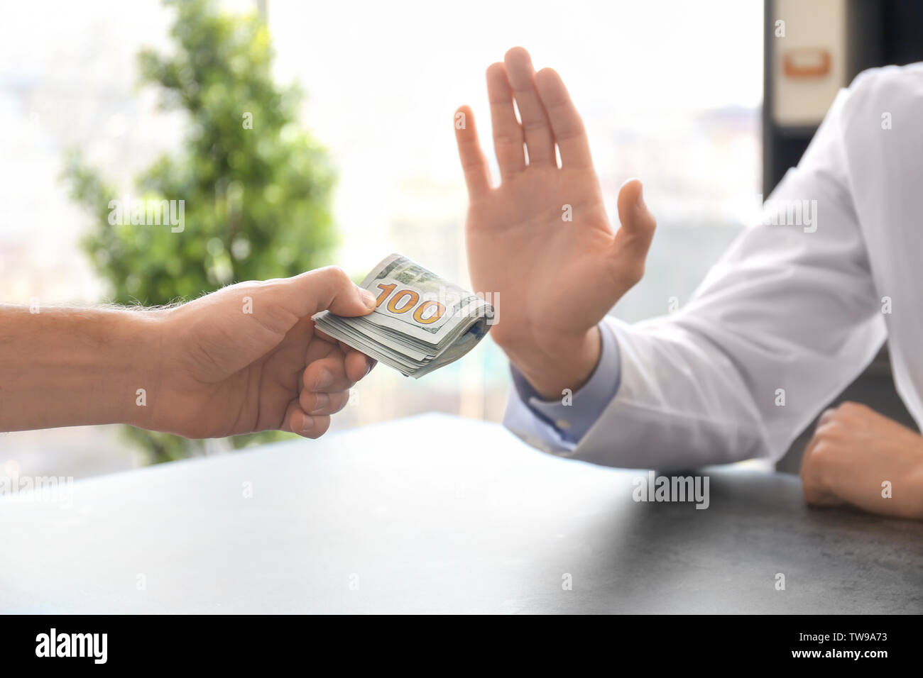 Doctor refusing to take bribe from patient at workplace Stock Photo - Alamy