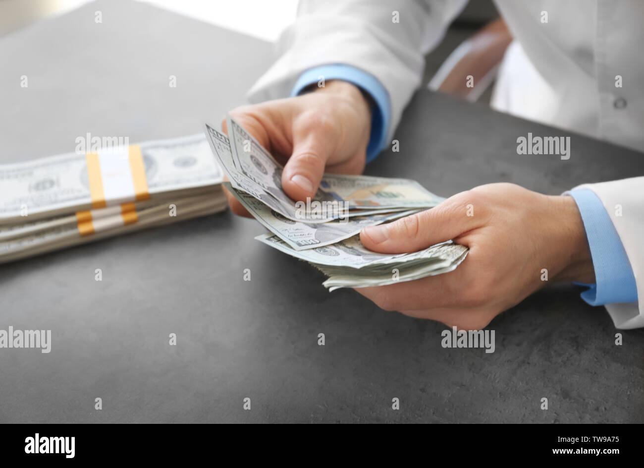 Doctor with bribe at workplace Stock Photo - Alamy