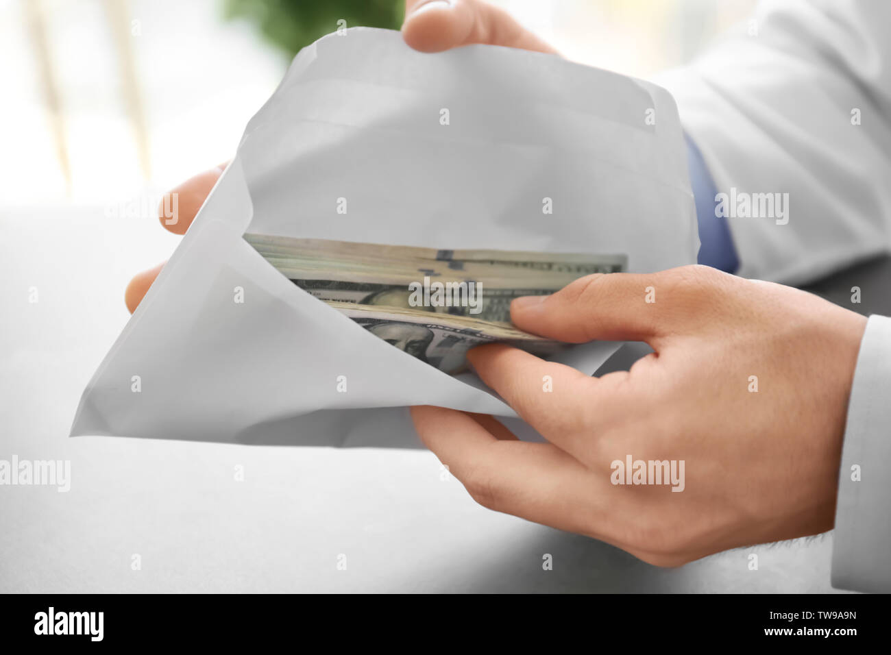 Doctor with bribe at workplace, closeup Stock Photo - Alamy