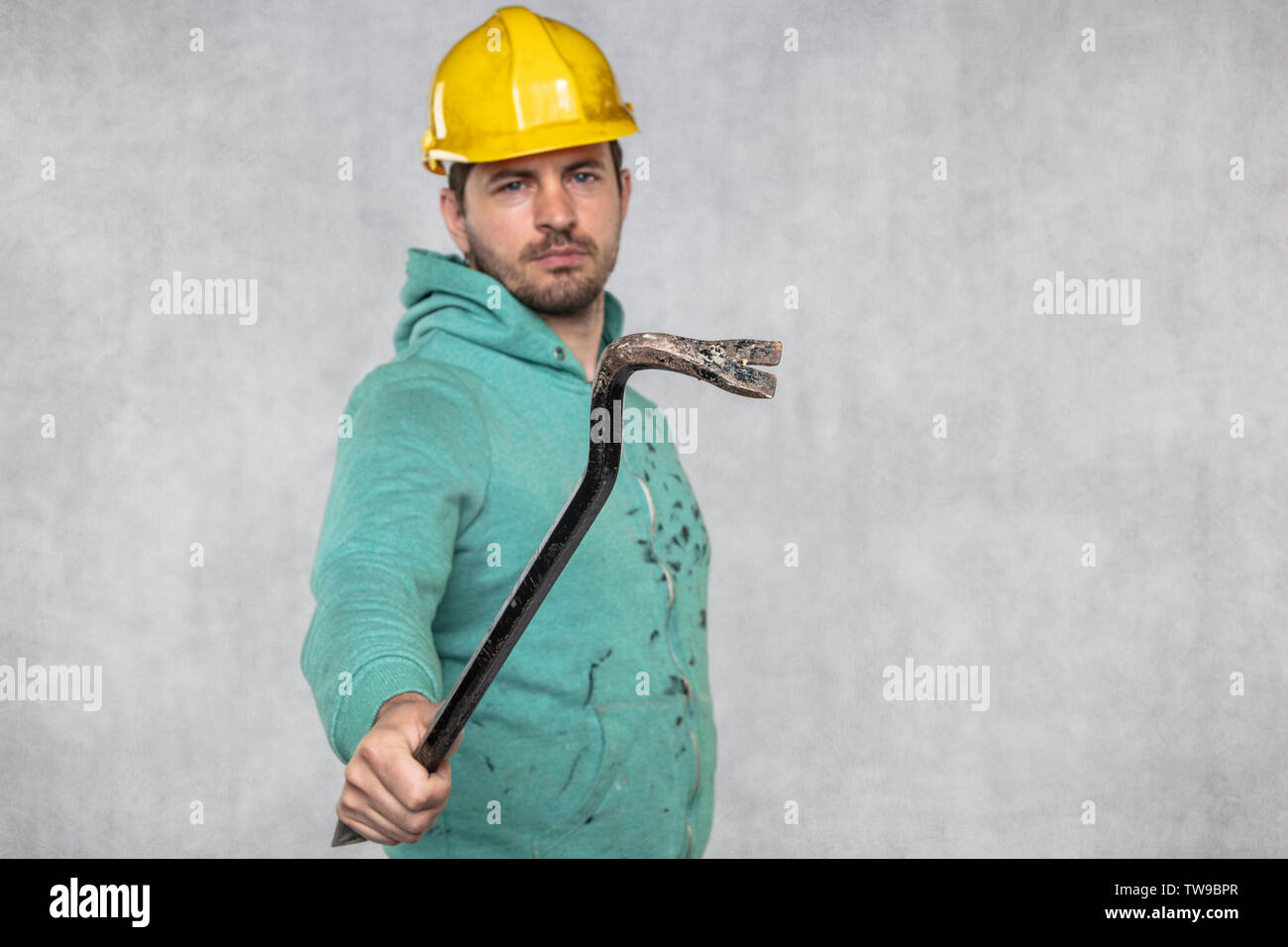 the construction worker holds a work tool in his hands, a crowbar Stock ...