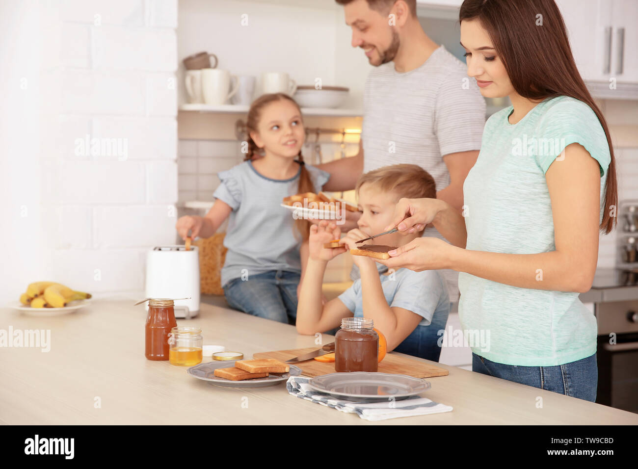 Happy family having breakfast with toasts in kitchen Stock Photo - Alamy