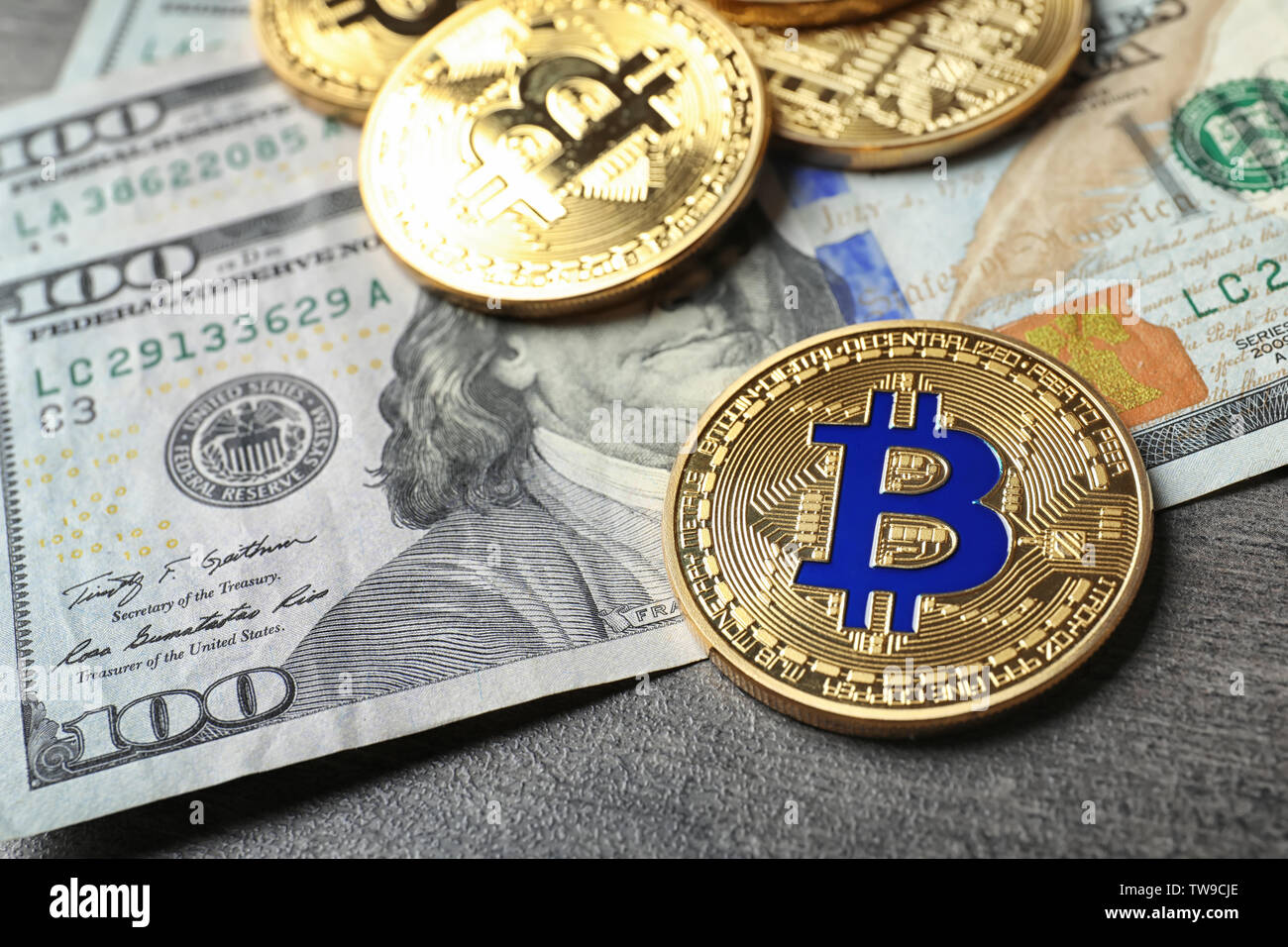 Golden bitcoins with dollar bills on table Stock Photo - Alamy
