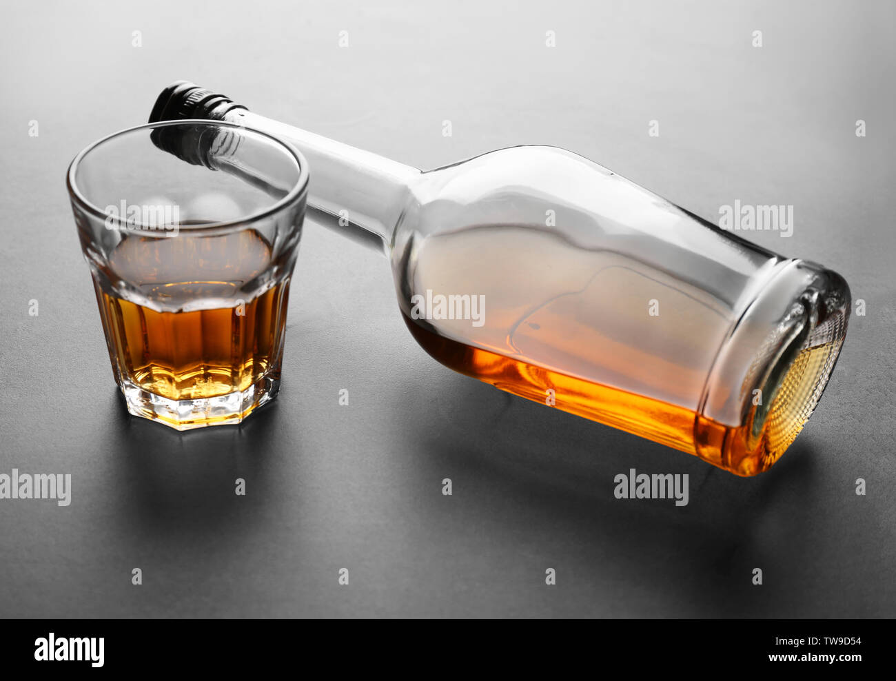 Glass and bottle of alcohol on grey background Stock Photo - Alamy