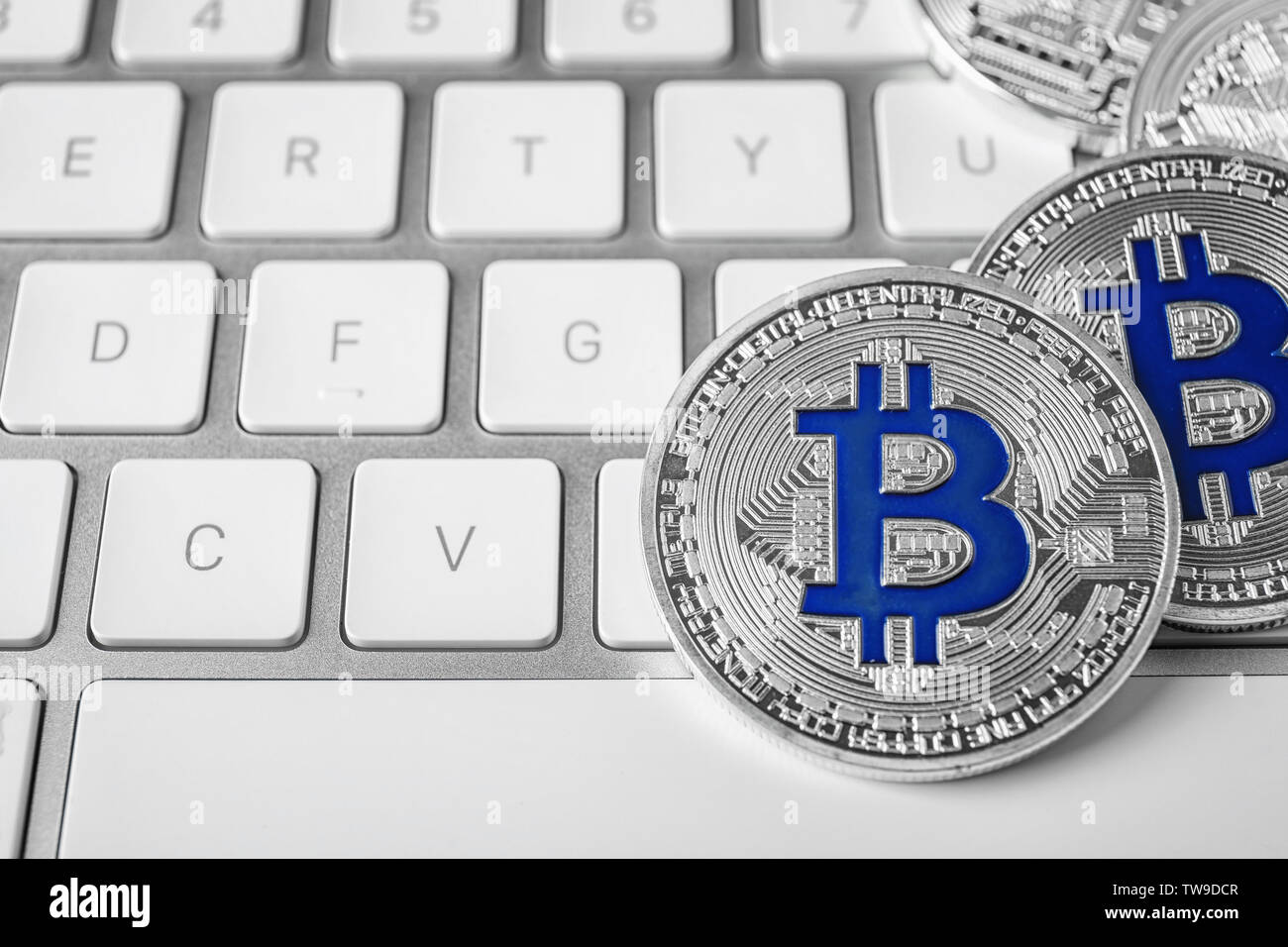Silver bitcoins on computer keyboard Stock Photo - Alamy