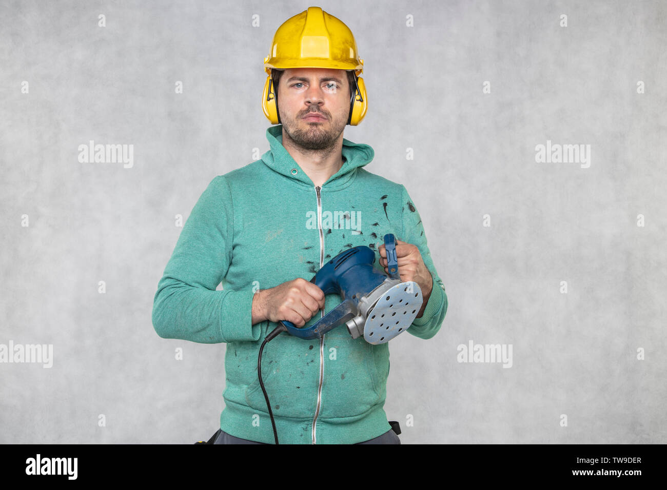 the construction worker holds a new grinder in his hand Stock Photo - Alamy