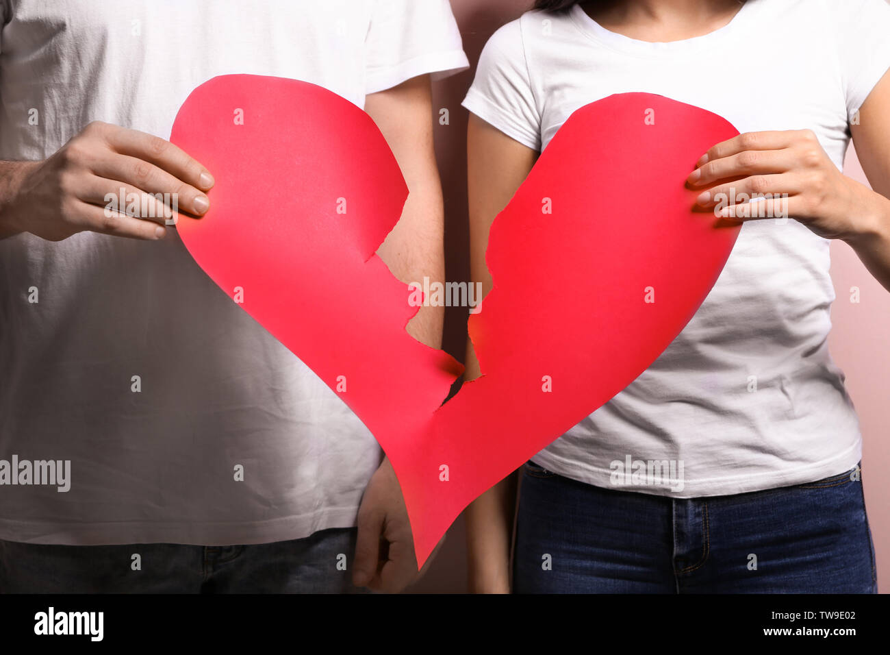 Couple tearing paper heart in half, closeup. Relationship problems ...