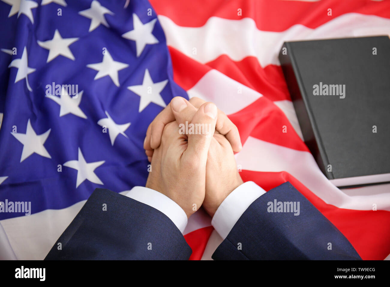 Man praying over American flag, closeup Stock Photo - Alamy