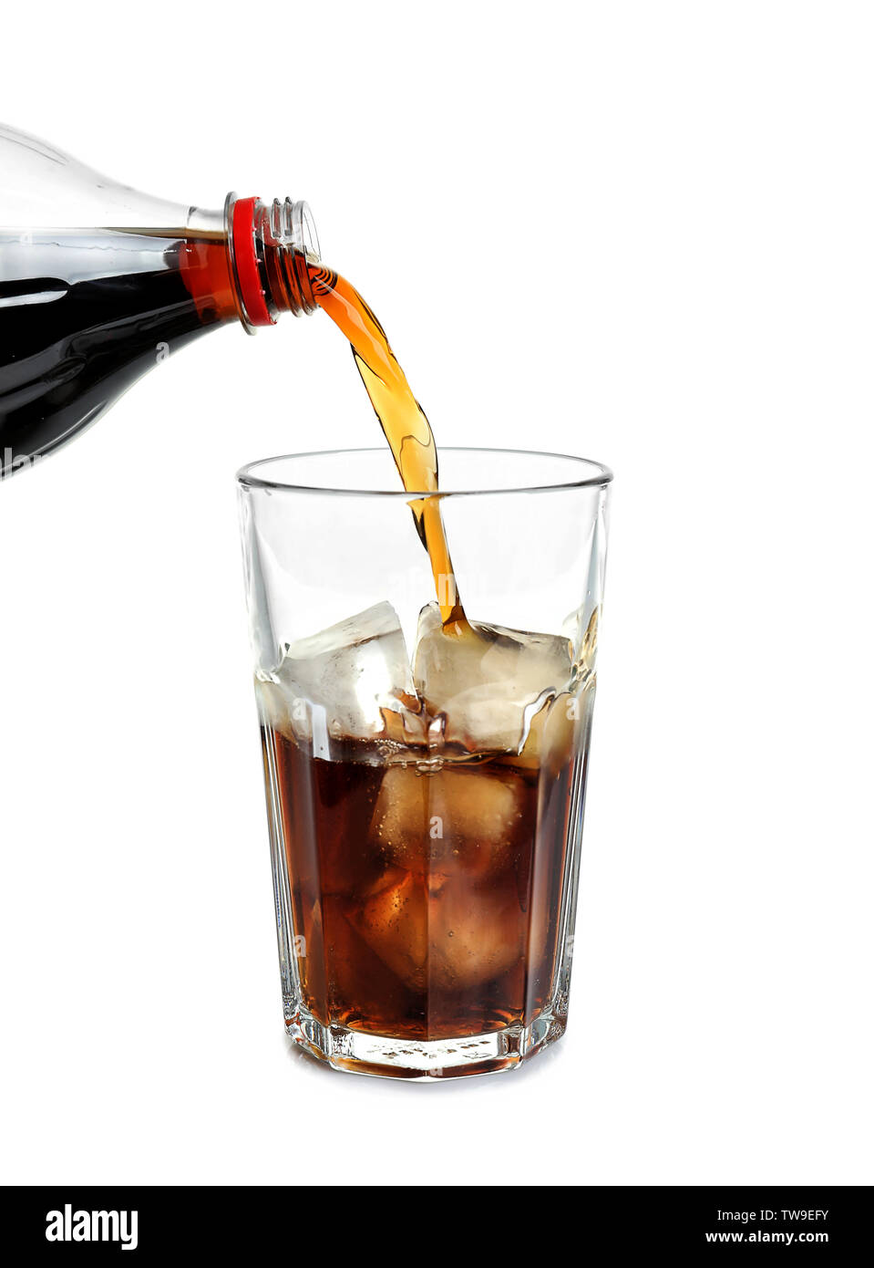 Cola pouring from bottle into glass with ice on white background Stock ...