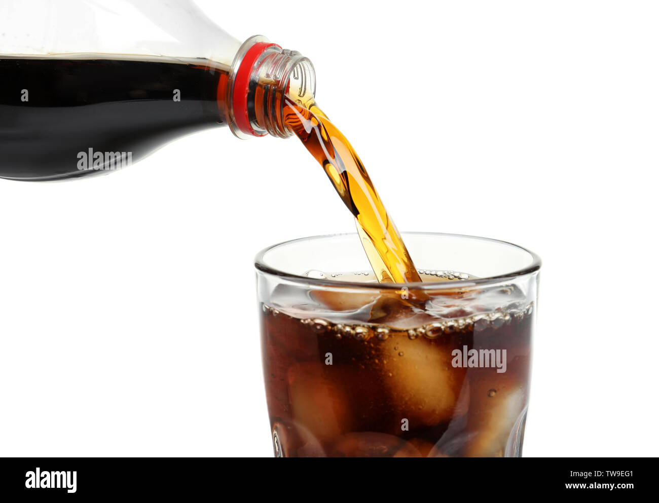 Cola pouring from bottle into glass with ice on white background Stock ...