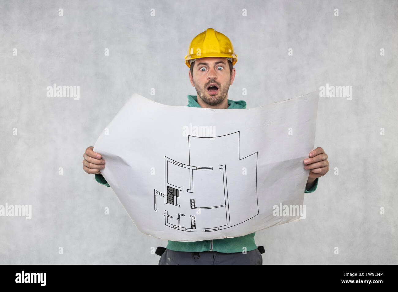 terrified builder shows apartment plans Stock Photo - Alamy