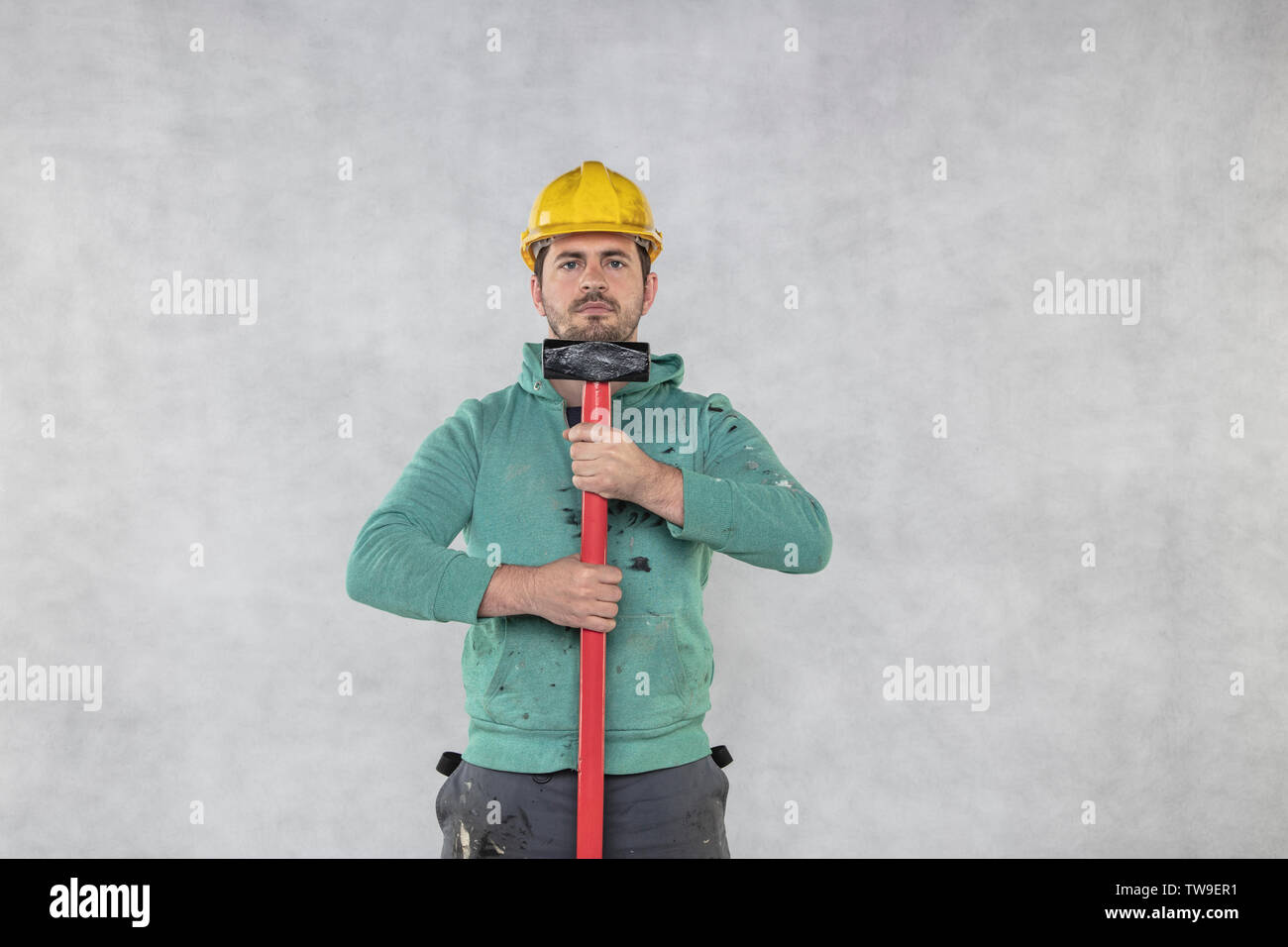 the construction worker is holding a hammer, ready for demolition tasks ...