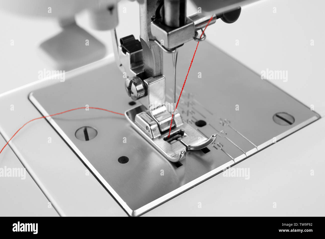 Modern sewing machine with thread, closeup Stock Photo - Alamy