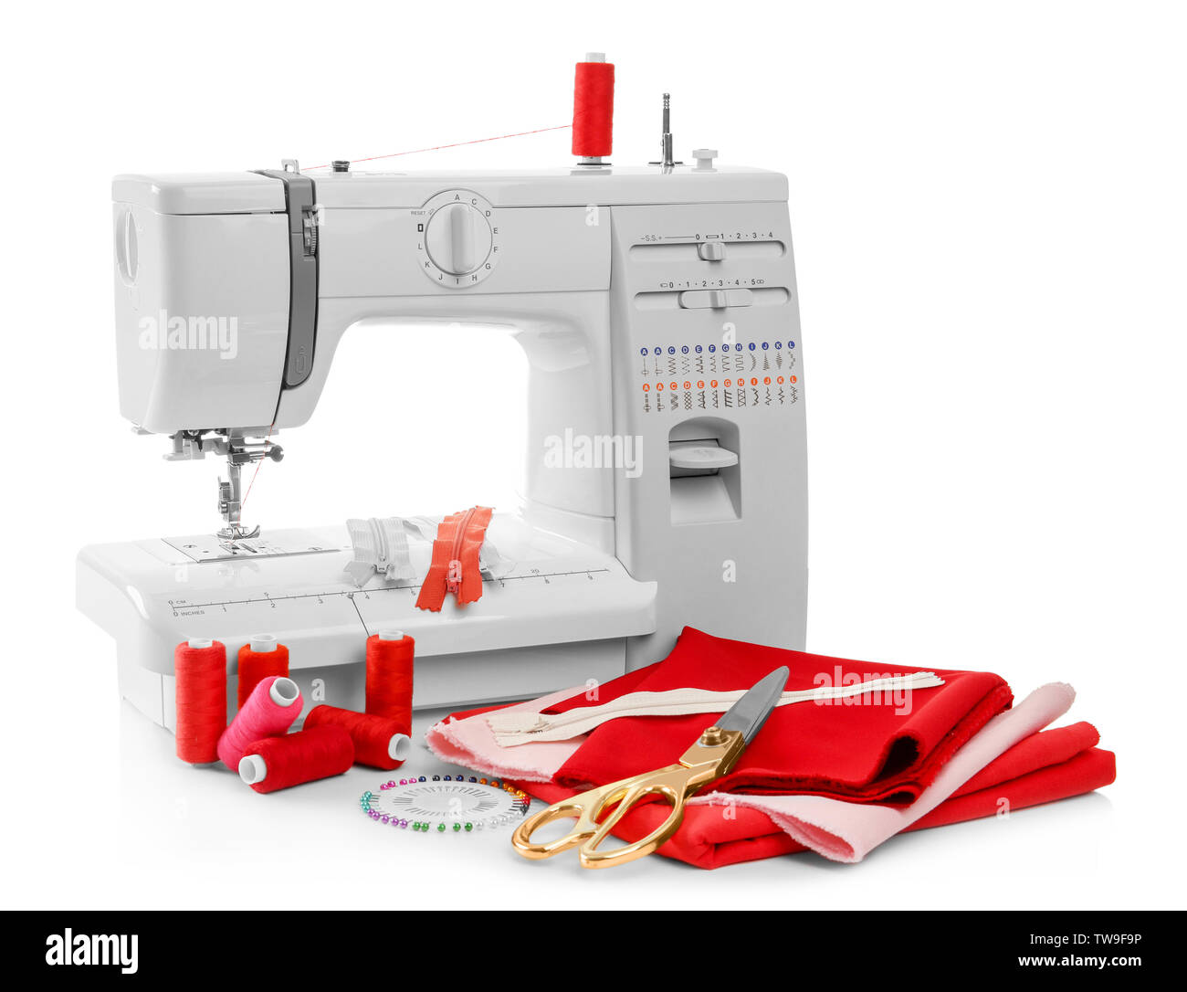 Modern sewing machine with threads and fabrics on white background ...