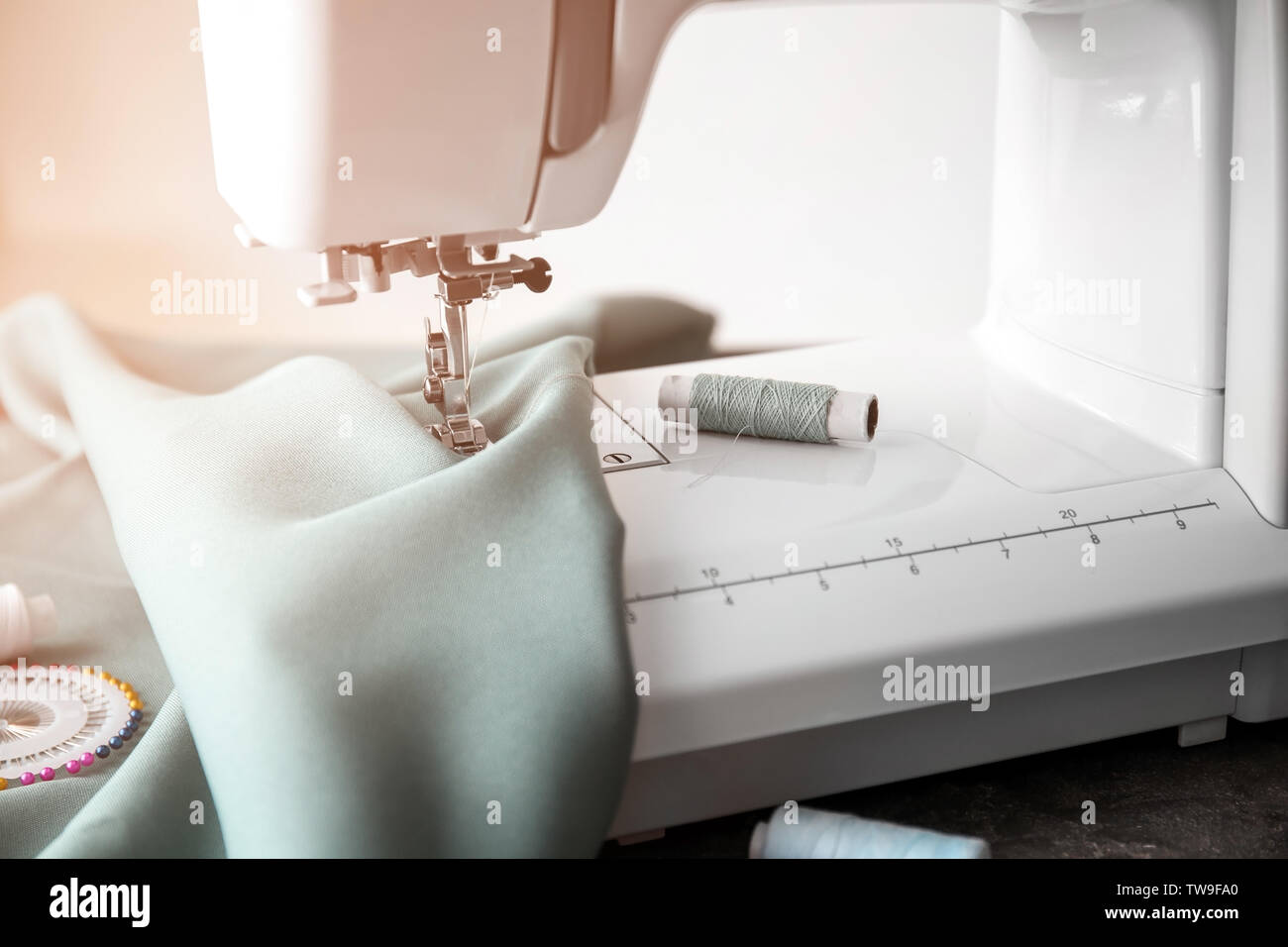 Modern sewing machine with fabric and threads, closeup Stock Photo - Alamy