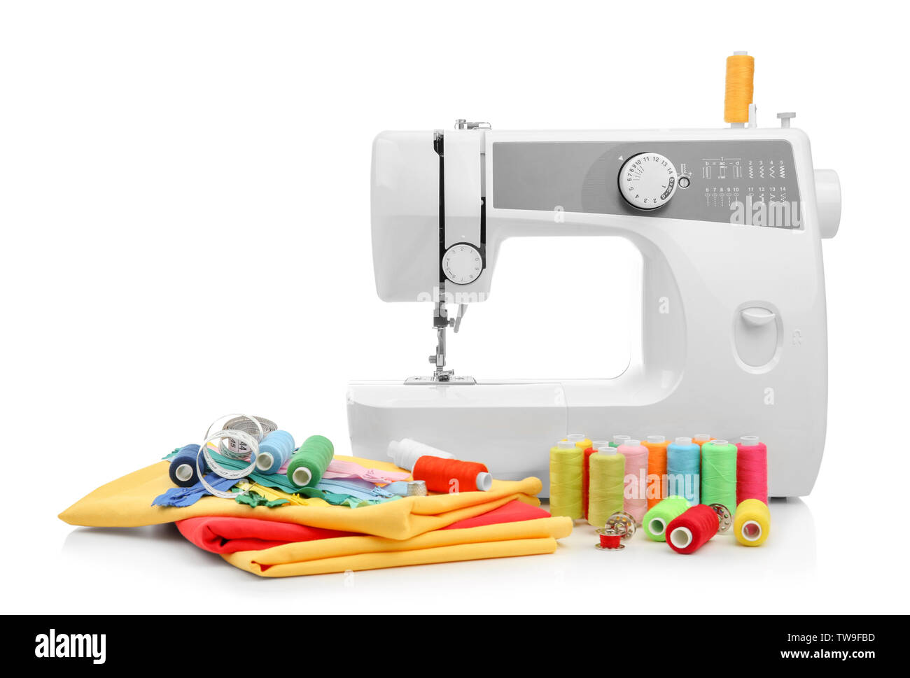 Modern sewing machine with threads and fabrics on white background ...