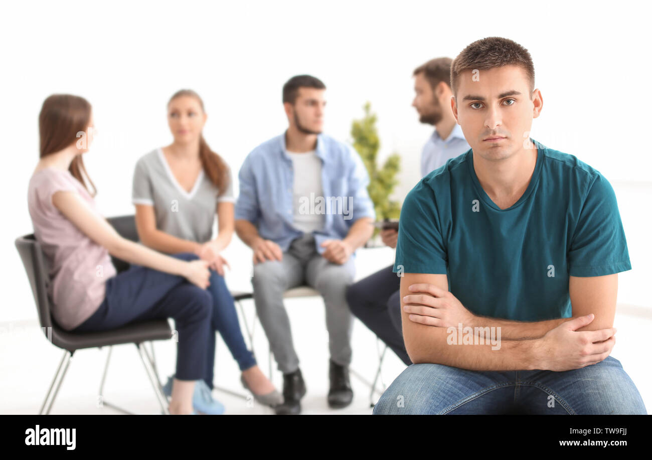 Sad young man at group therapy session Stock Photo - Alamy