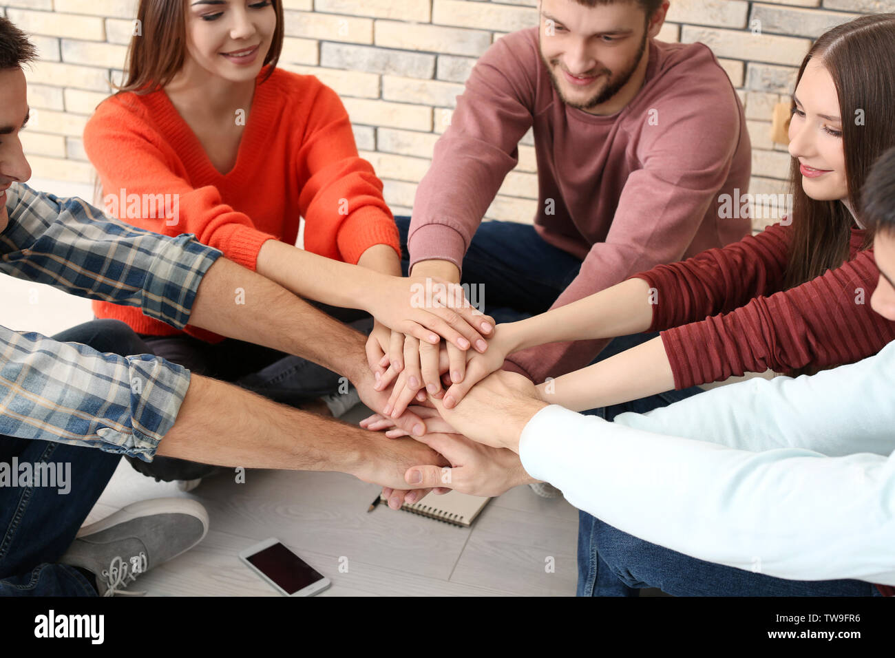 People putting hands together, indoors. Unity concept Stock Photo - Alamy