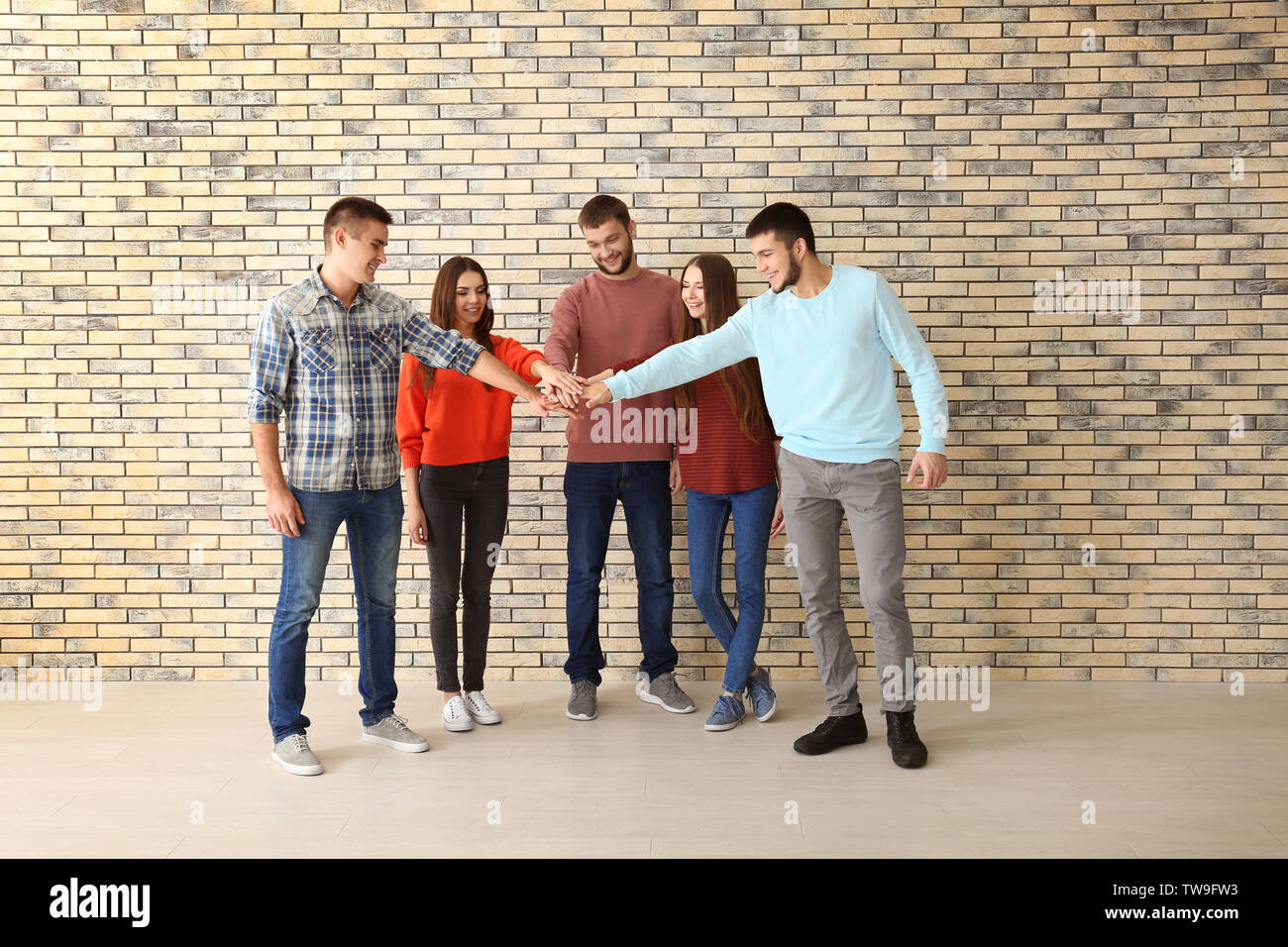 People putting hands together, indoors. Unity concept Stock Photo - Alamy