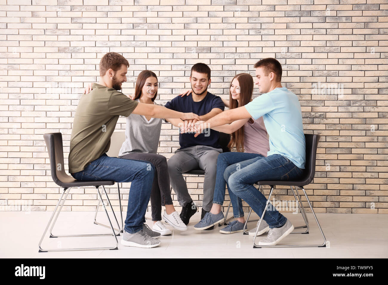 People putting hands together, indoors. Unity concept Stock Photo - Alamy