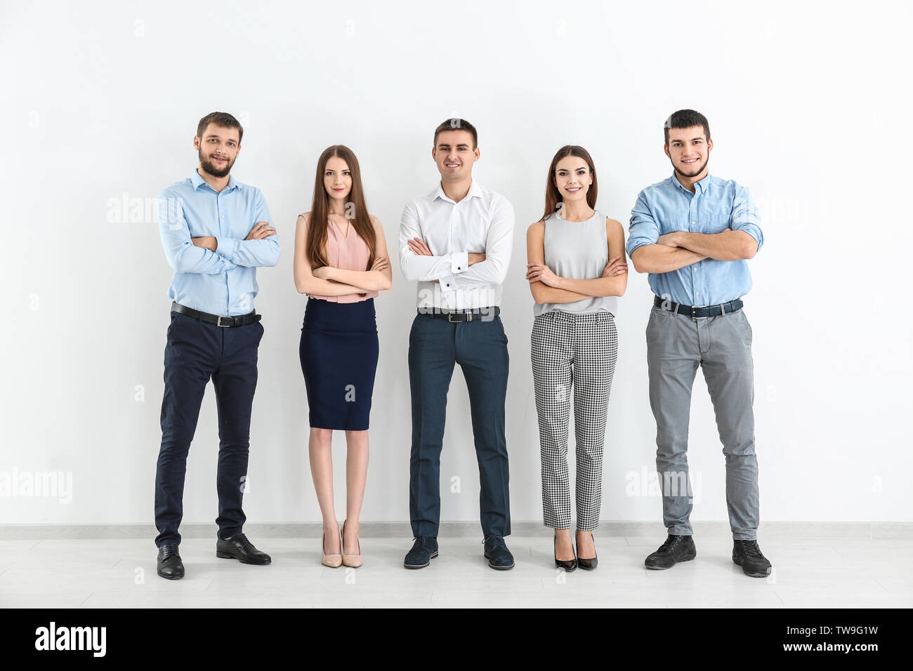 Young people standing together on white wall background. Unity concept ...