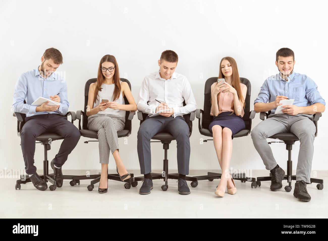 Group of young people sitting on chairs together, indoors. Unity ...
