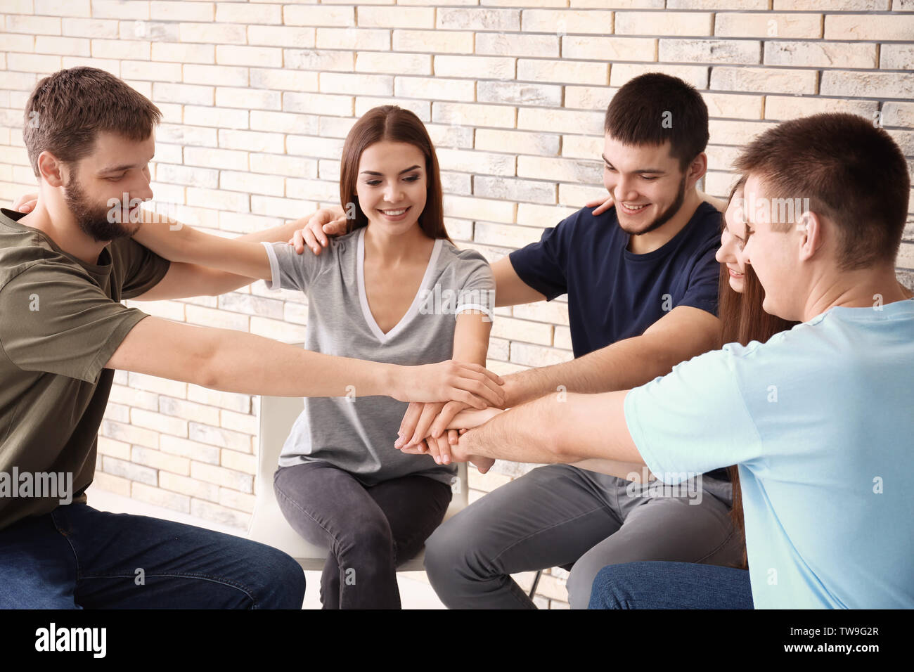 People putting hands together, indoors. Unity concept Stock Photo - Alamy