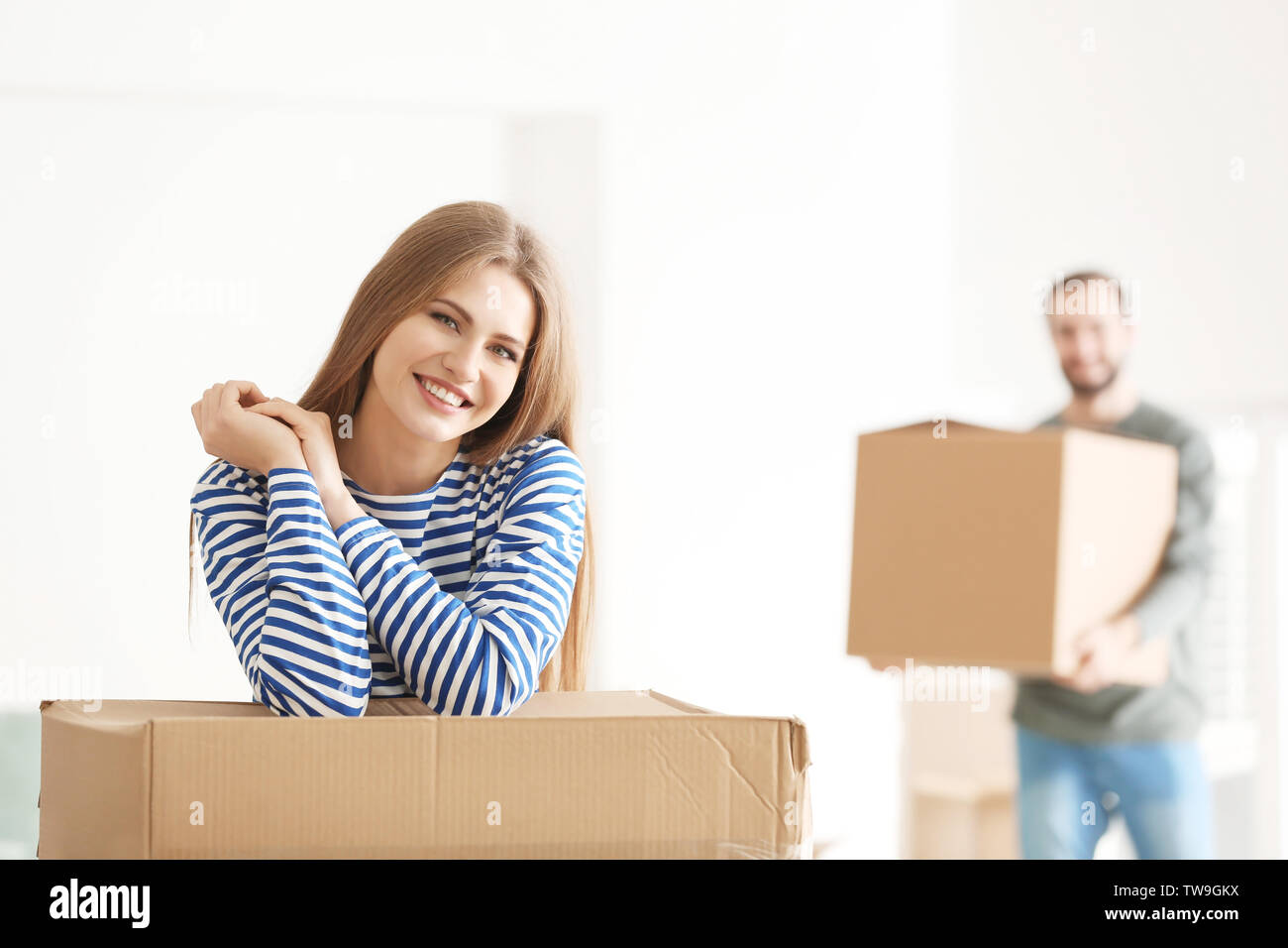 Young woman with moving box in room at new home Stock Photo - Alamy