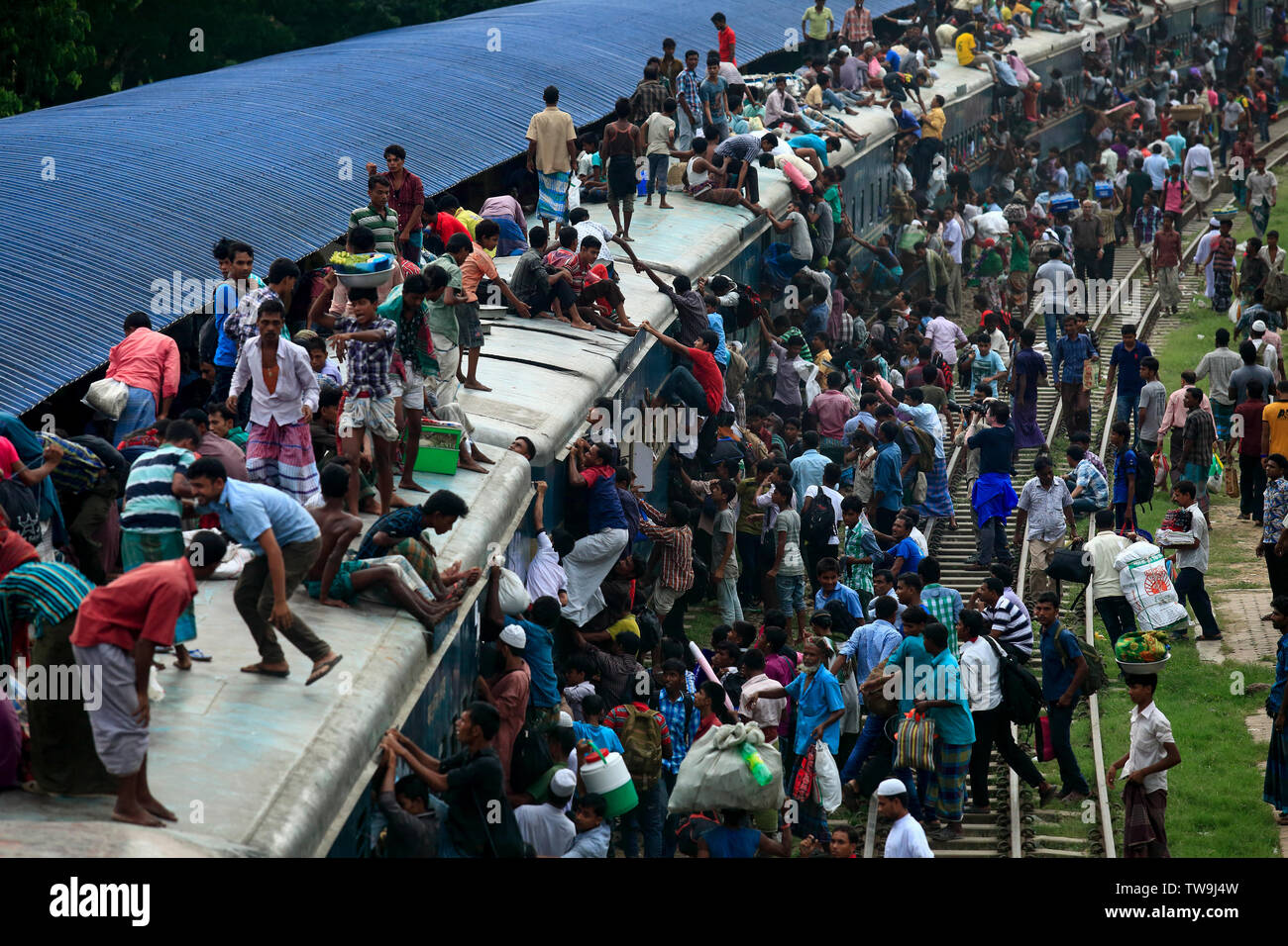 Home-bound people struggle to get the rooftop of the train at Airport ...