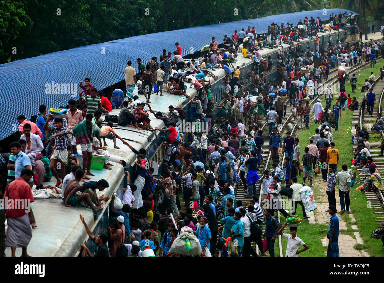 Home-bound people struggle to get the rooftop of the train at Airport ...