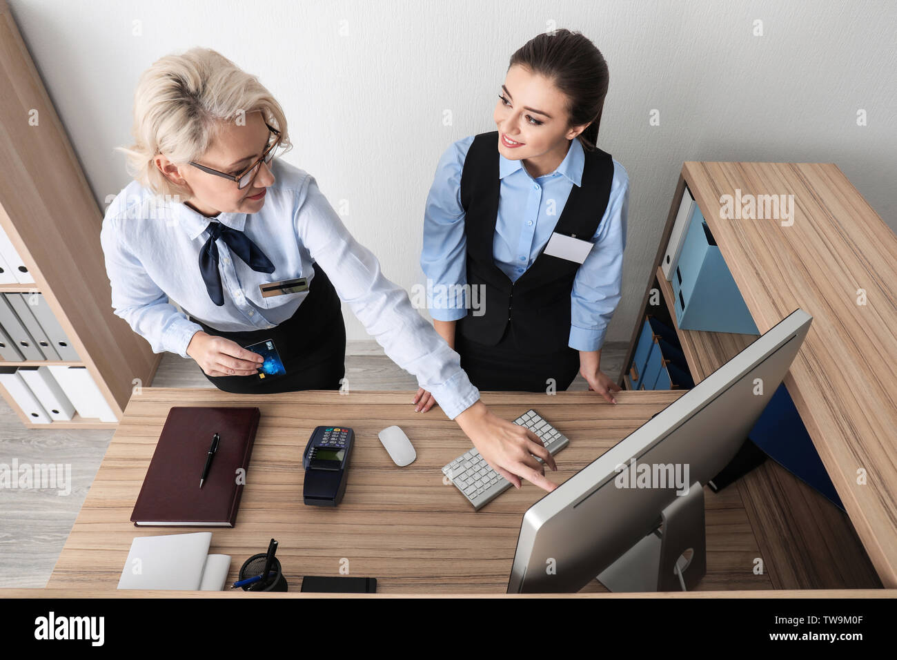 Female receptionist teaching trainee in hotel Stock Photo - Alamy